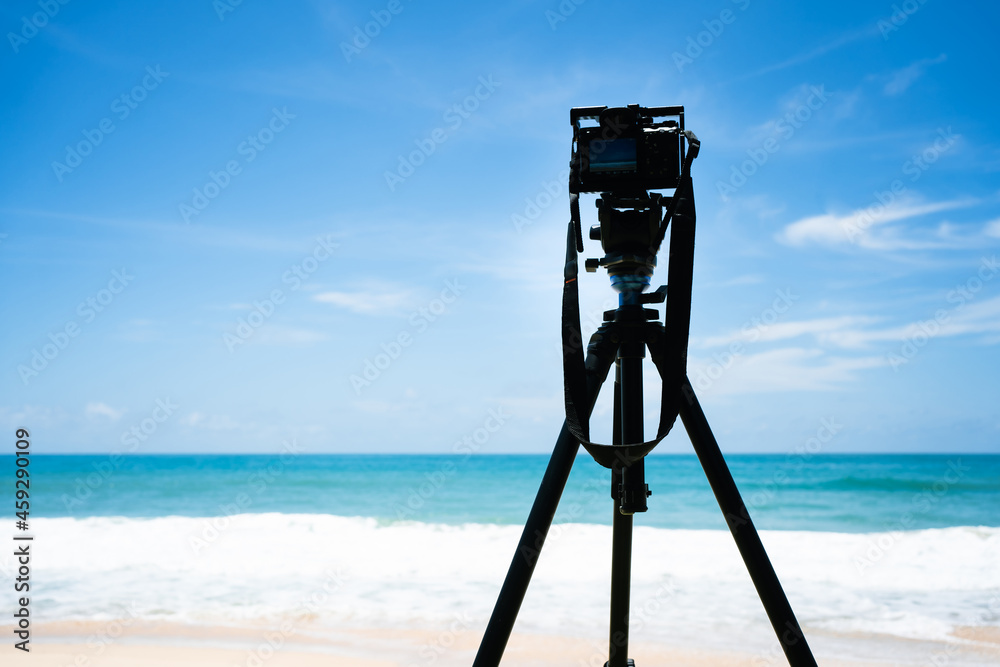 Camera set up on tripod shooting beach sea sunny day. Shooting photo ...