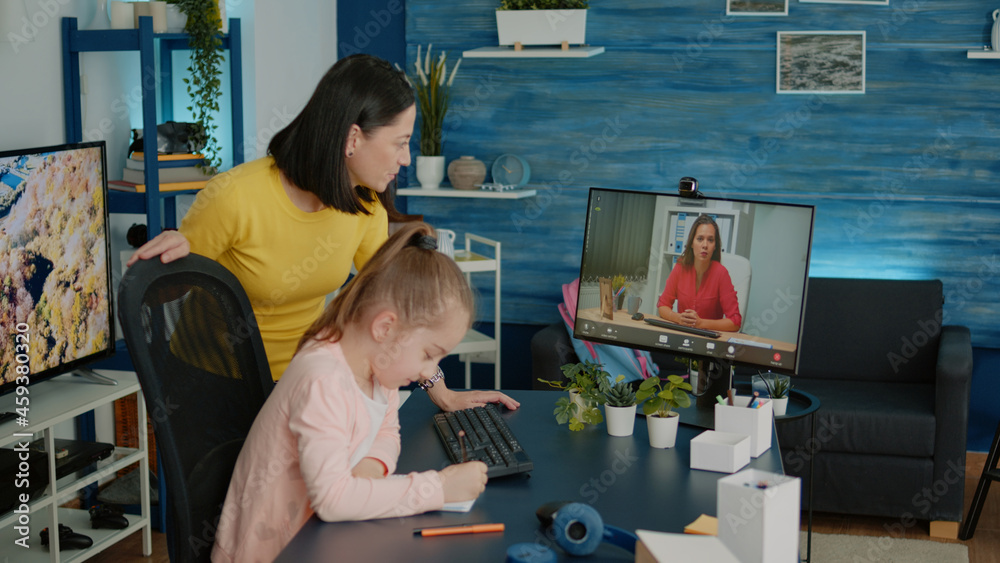 Child and mother using video call with teacher for online lesson and ...