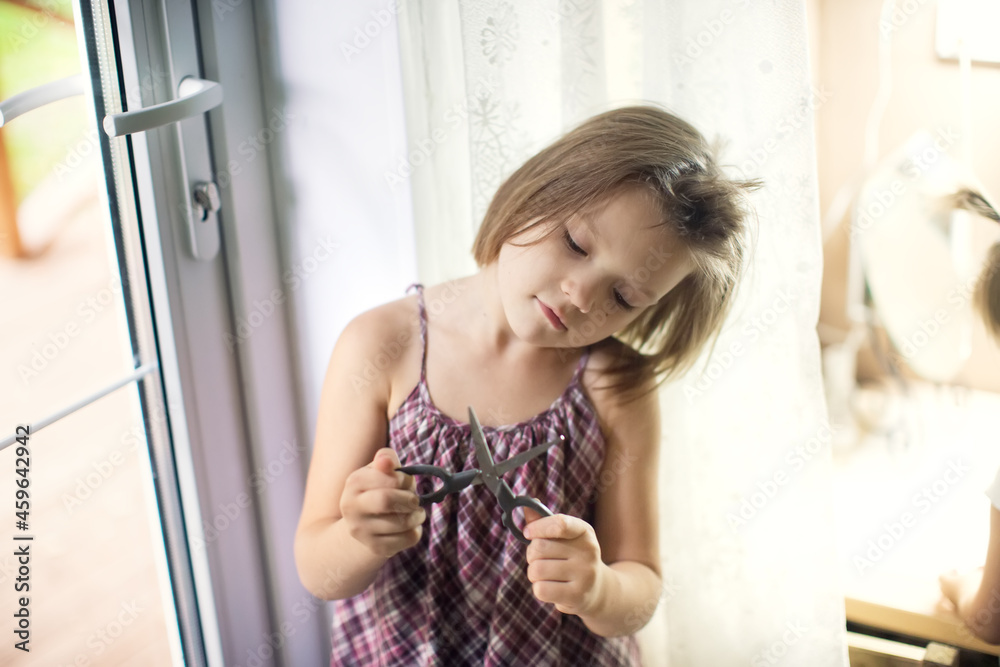 Emotional sad offended Caucasian girl child with scissors cuts off his ...