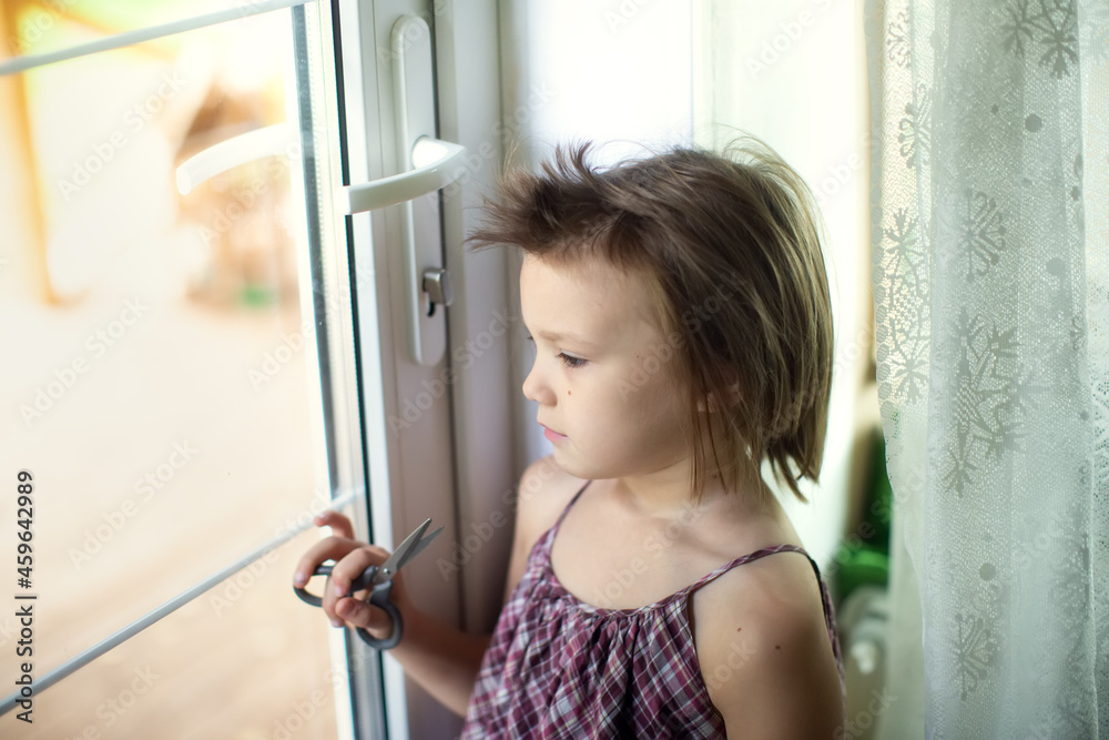 Emotional sad offended Caucasian girl child with scissors cuts off his ...