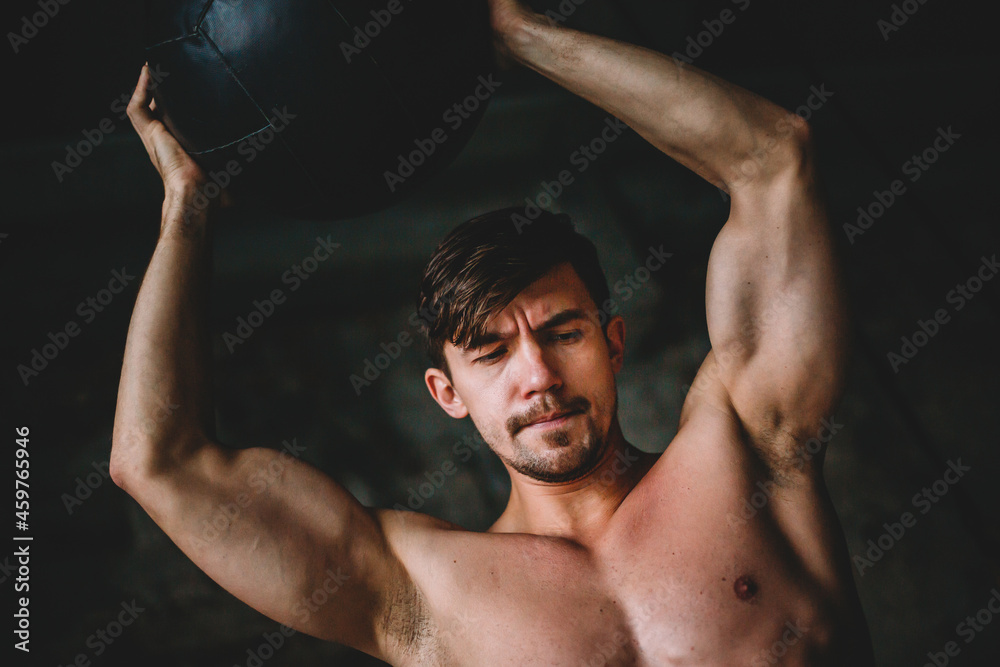 Foto de Stock The man raised a black medical ball over his head. He's ...