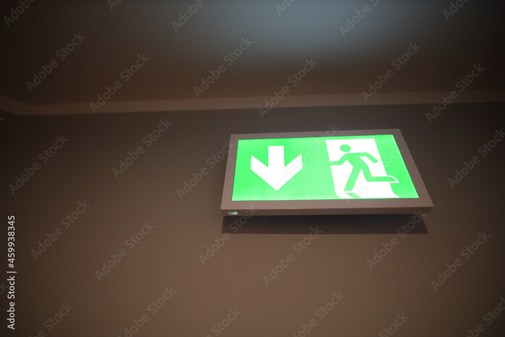 Emergency exit sign on the office wall Stock Photo | Adobe Stock