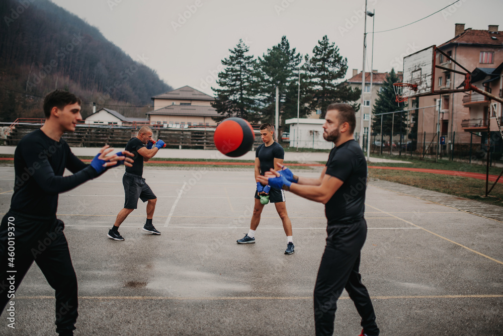 Professional boxers doing boxing exercises outdoor with their trainer ...