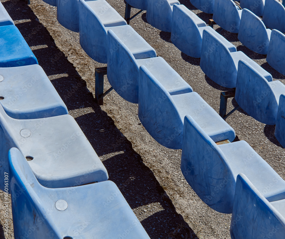 Rows of stadium grandstand seat. Rusty plastic blue and white stadium ...