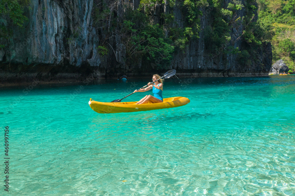 Woman on a kayak in the Small Lagoon with azure water, El Nido, Palawan ...
