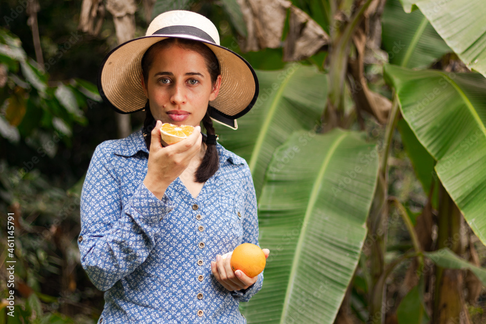 Peasant woman in Latin America, eating oranges in the fields of Peru ...