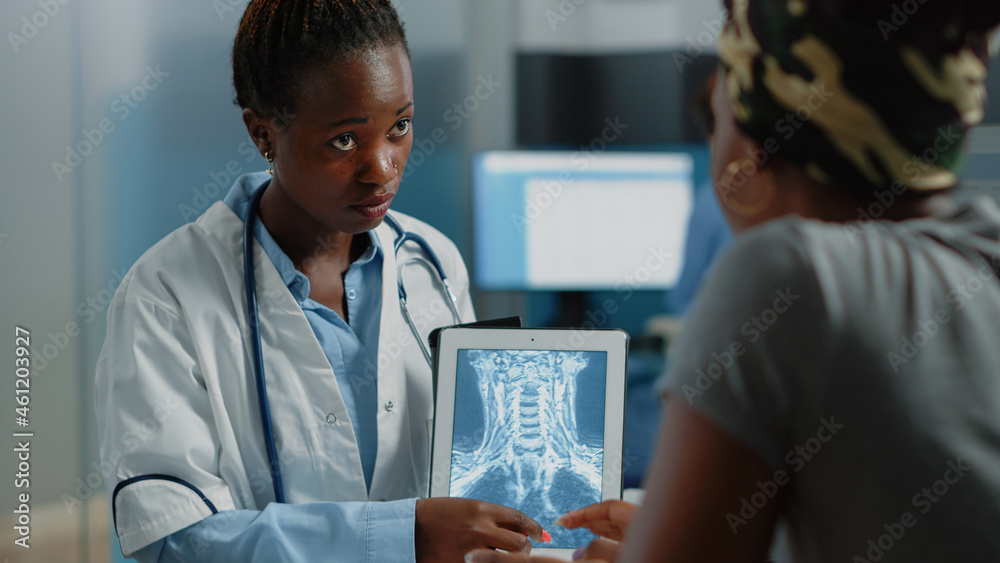 Woman working as doctor with radiography on tablet for checkup visit ...