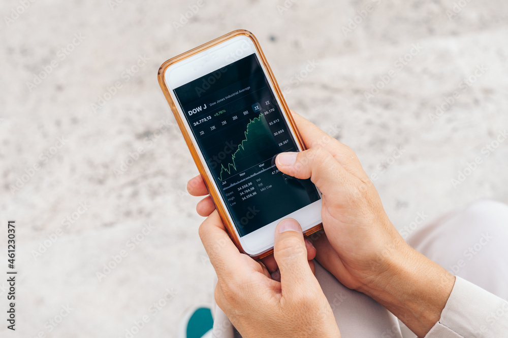 Stock-Foto „Stock market investor hands holding a phone investment app ...