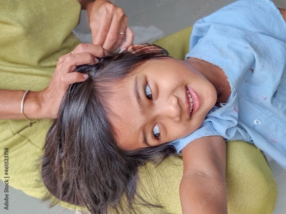 Asia happy rural family. A mother is trying to poke her daughter's hair ...