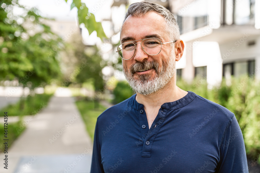 Mature man walking outside in city background Stock Photo | Adobe Stock