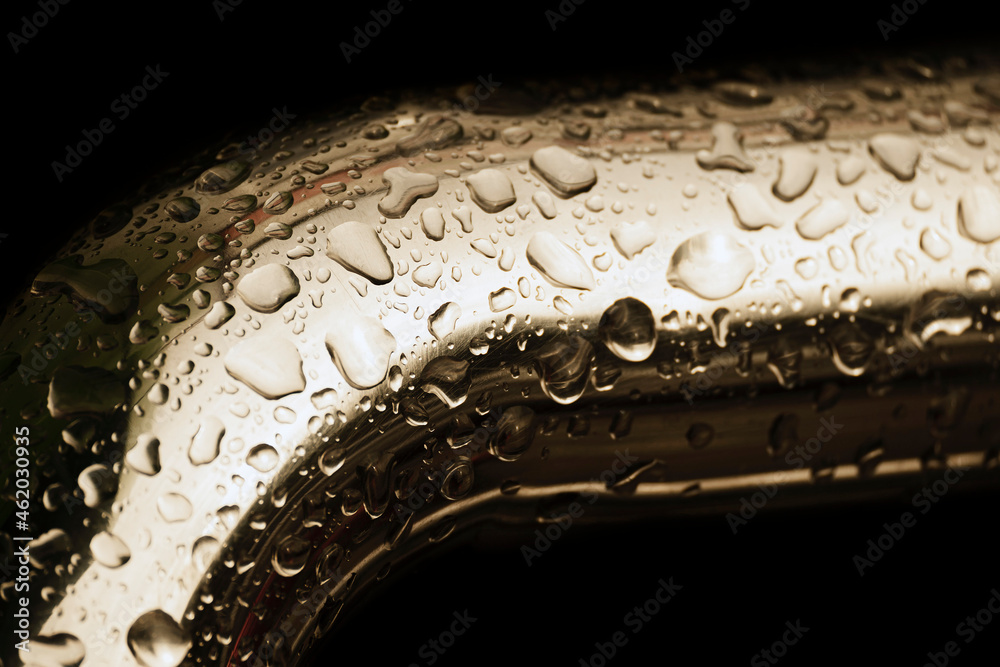 Abstract background. Yellow metal pipe covered water droplets ...