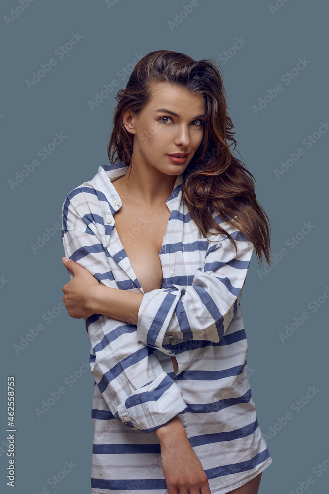 Sexy young woman with long wavy auburn hair in a provocative pose ...