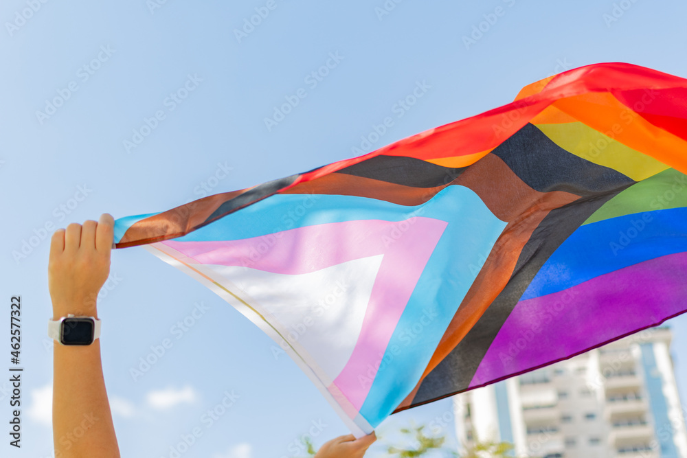 Progress pride flag (new design of rainbow flag) waving in the air with ...