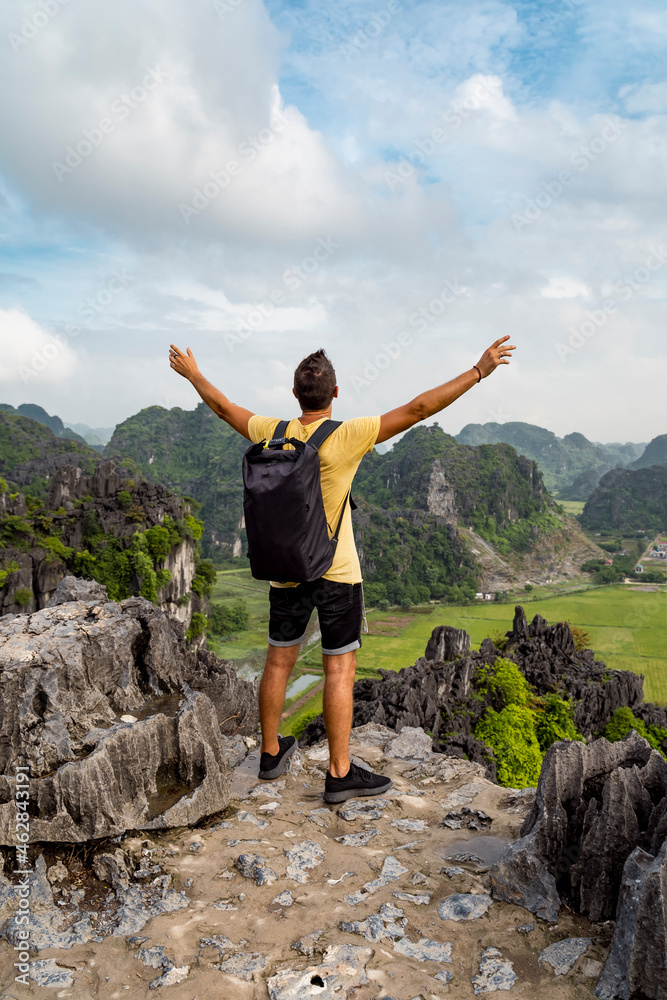 Vietnam, Ninh Binh Province, Ninh Binh, Male hiker standing with raised ...