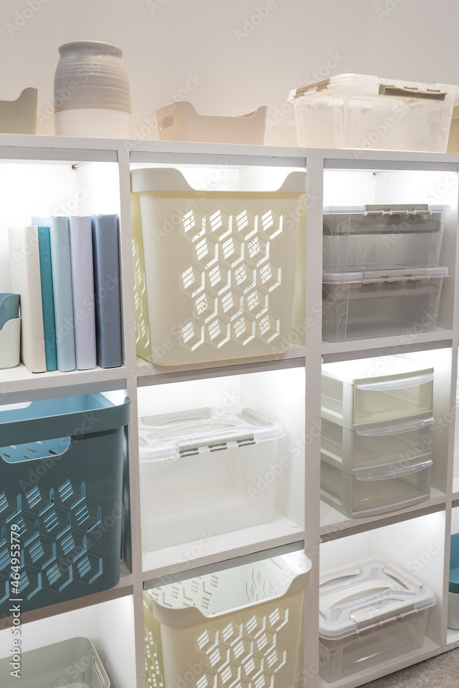 Plastic container boxes on a shelf on a rack for organizing home space ...