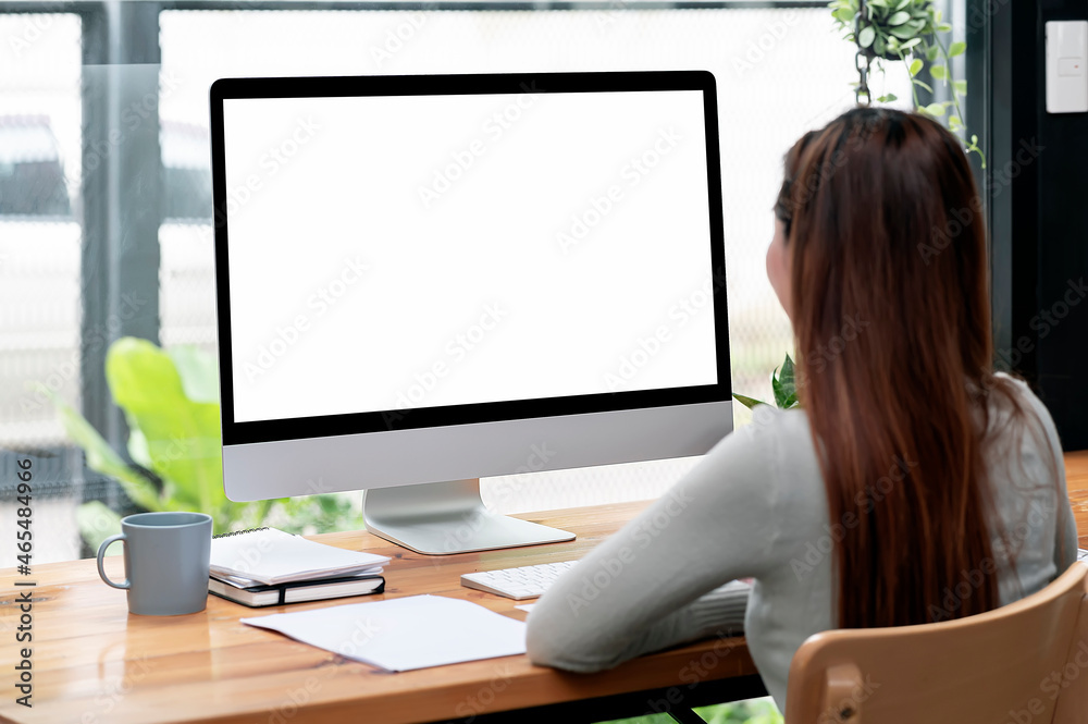 Rear view of young woman working on desktop computer at home. Stock ...