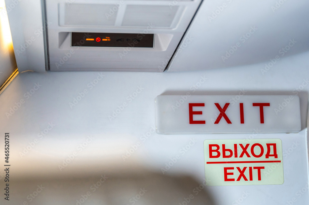 Emergency exit sign on the plane. No smoking sign in the cabin during ...