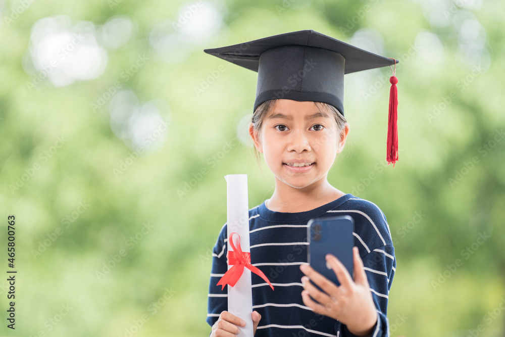 Happy Asian female kid graduate with graduation cap and rolled ...