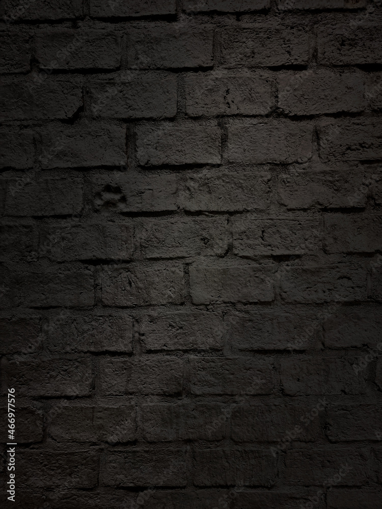 close up shot at the surface of black bumpy brick pattern wall with ...