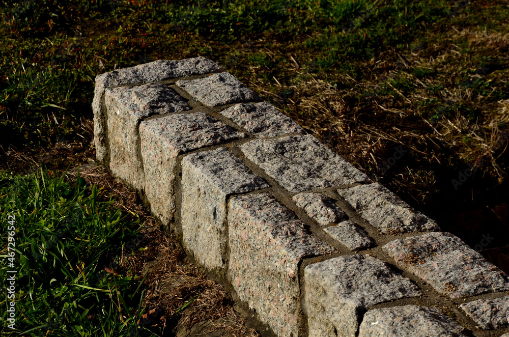 Granite walls made of stone blocks serve as design elements, retaining ...