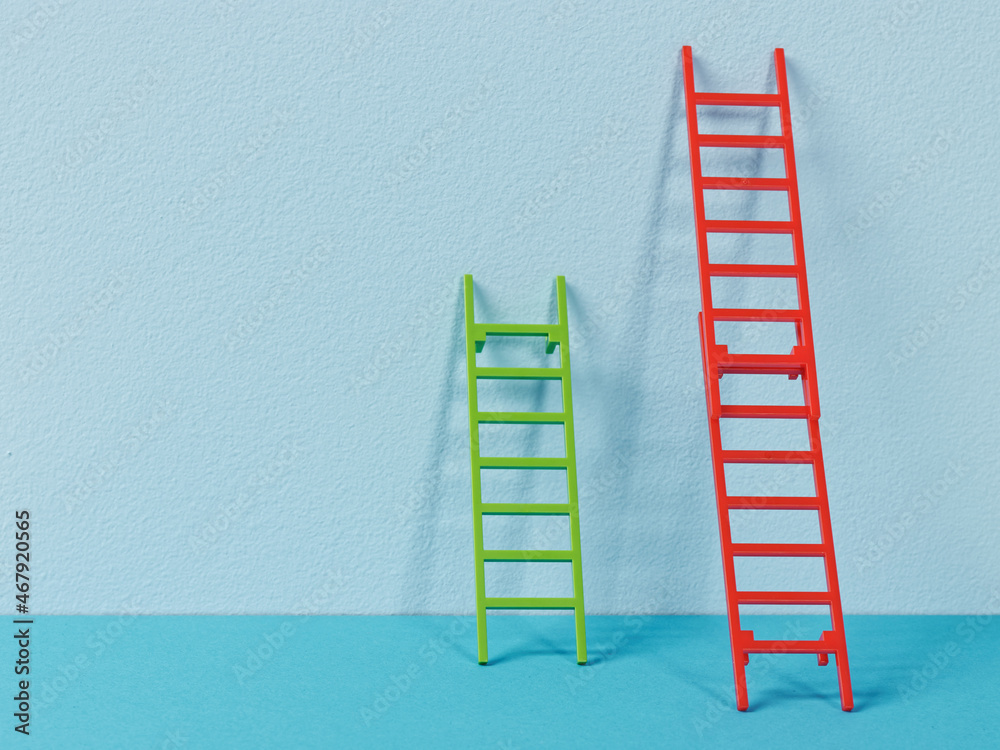 Two different height ladders. Plastic toy smaller and bigger ladder on ...