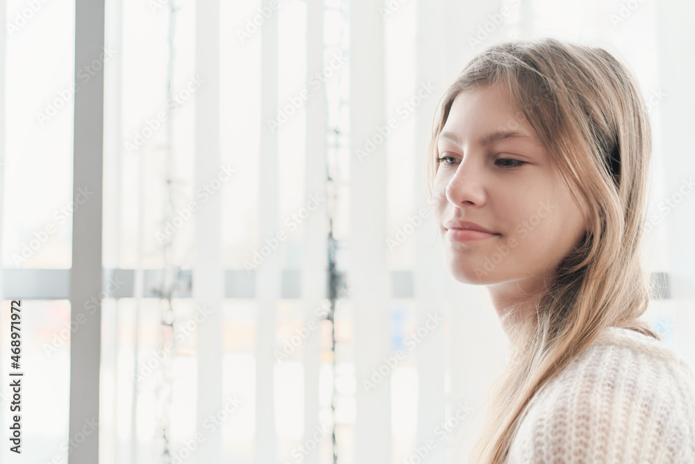 calm and peaceful teenager girl sitting in front of a window. beautiful ...