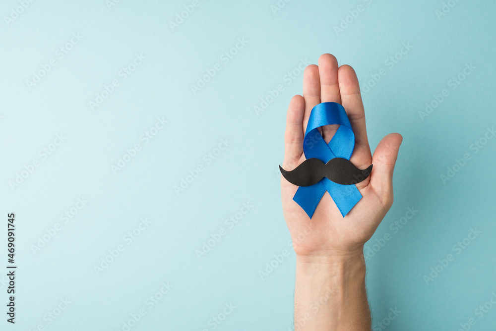 First person top view photo of male hand holding blue ribbon and ...