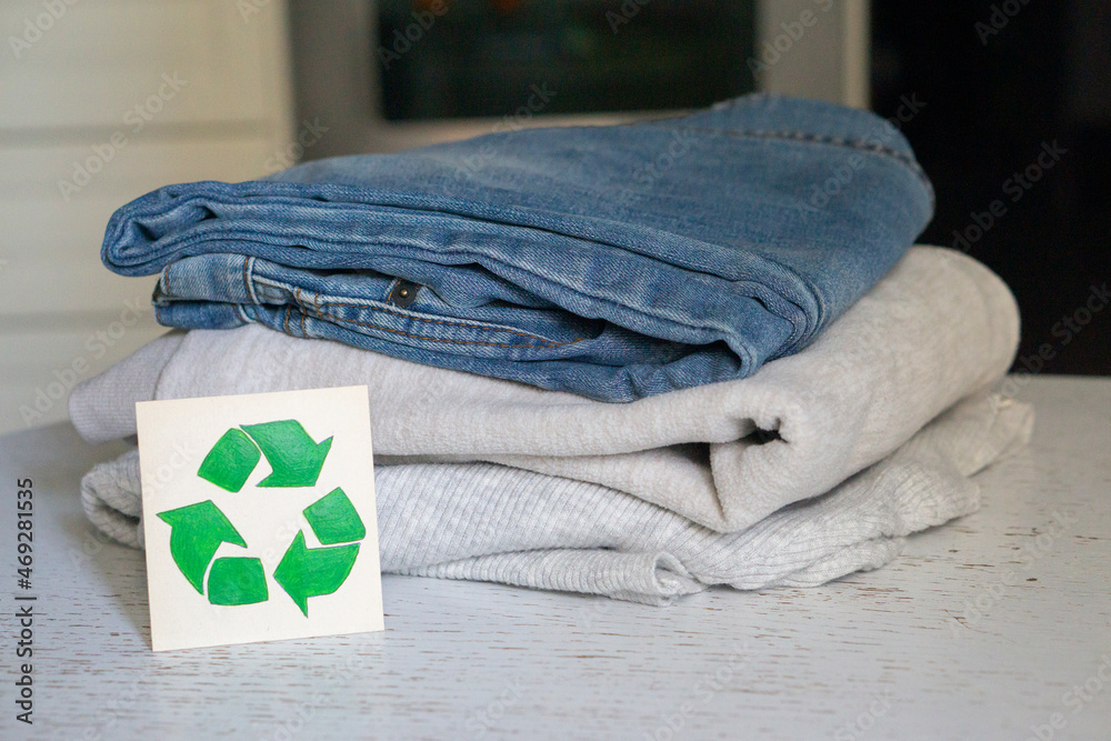 Garment recycling concept. A stack of clothes is on the recycling table ...