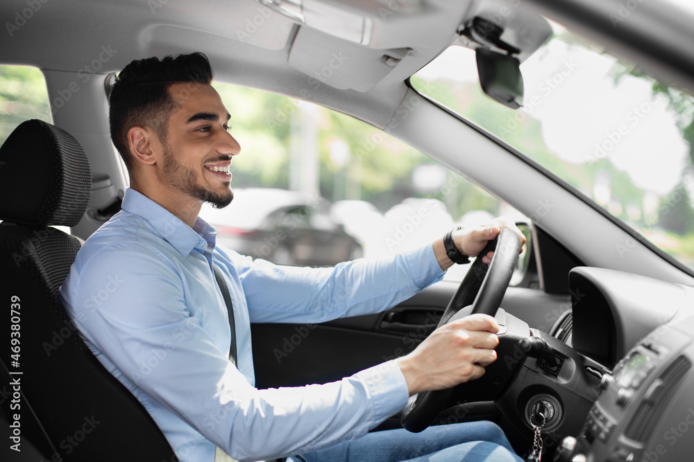 Joyful arabic guy driving nice auto, side view Stock Photo | Adobe Stock