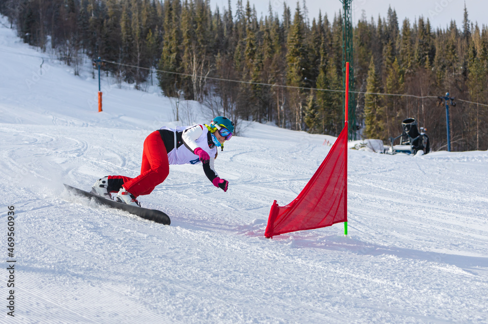 athlete girl with a hard snowboard for slalom in a ski resort enters ...