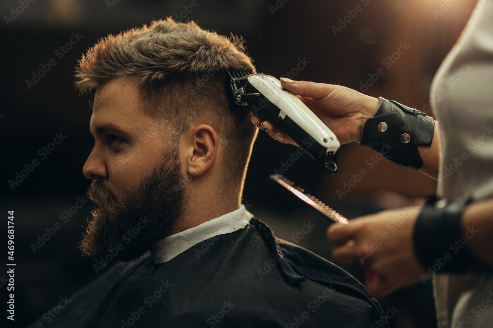 Young bearded man getting haircut by hairdresser Stock Photo | Adobe Stock