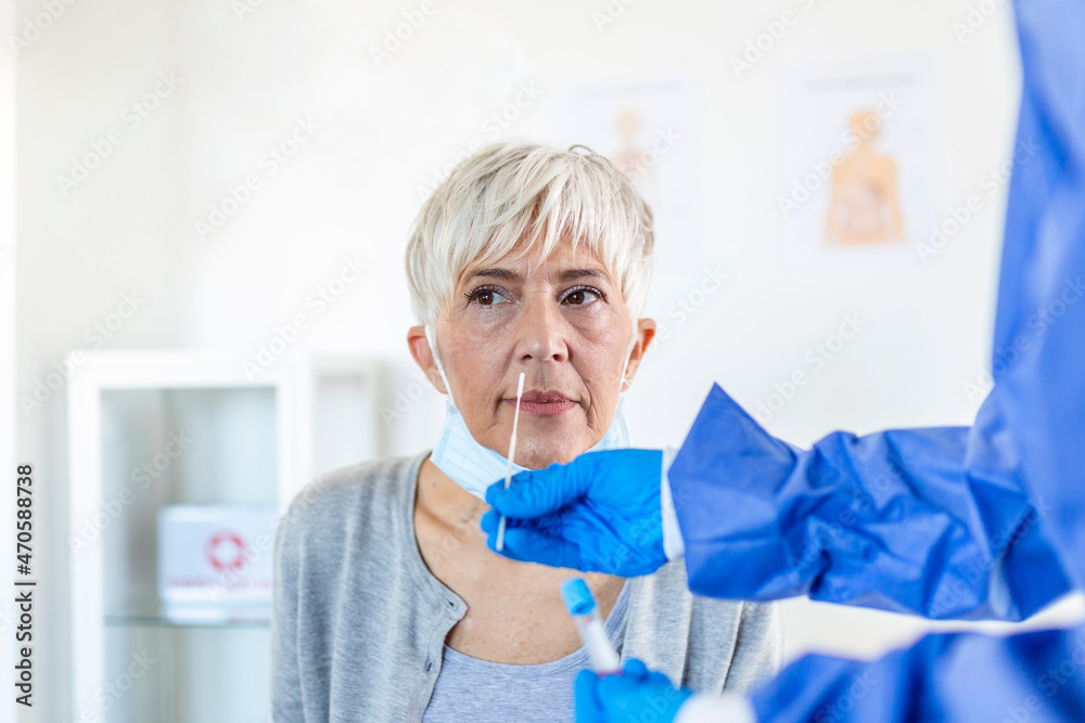 Physician wearing personal protective equipment performing a ...