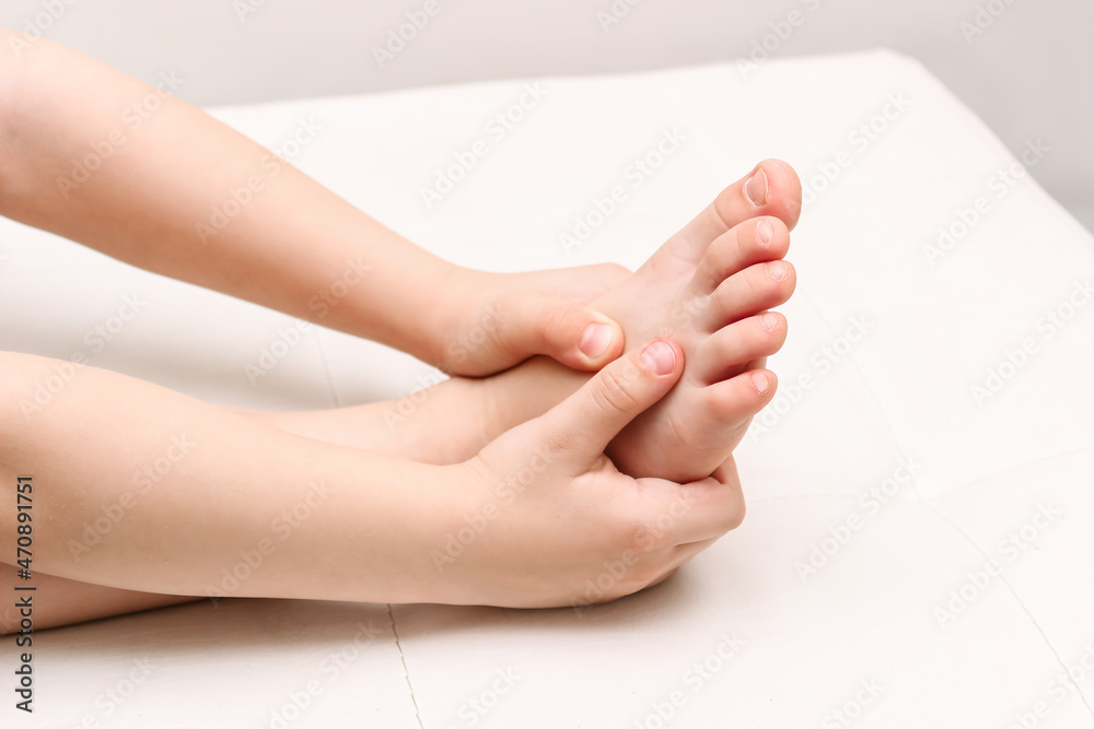 Pain in the foot and toes from uncomfortable shoes. A small kid holds a ...