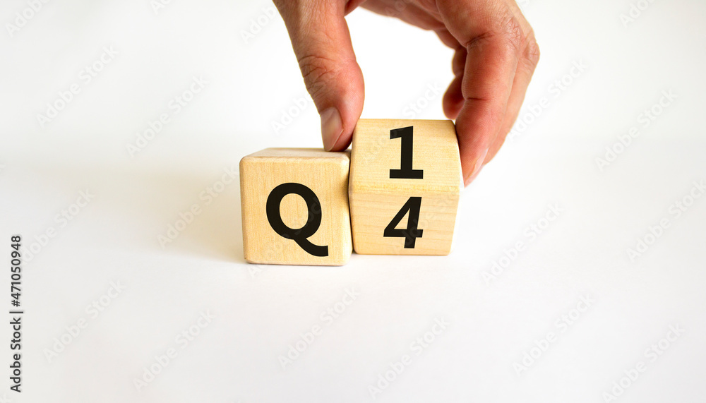 From 4th to 1st quarter symbol. Businessman turns a wooden cube and ...
