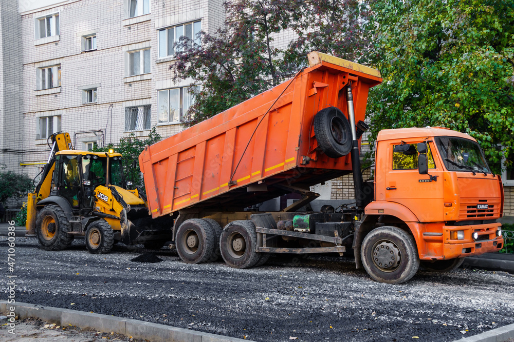 Road repair work to replace the asphalt pavement. A dump truck loads ...