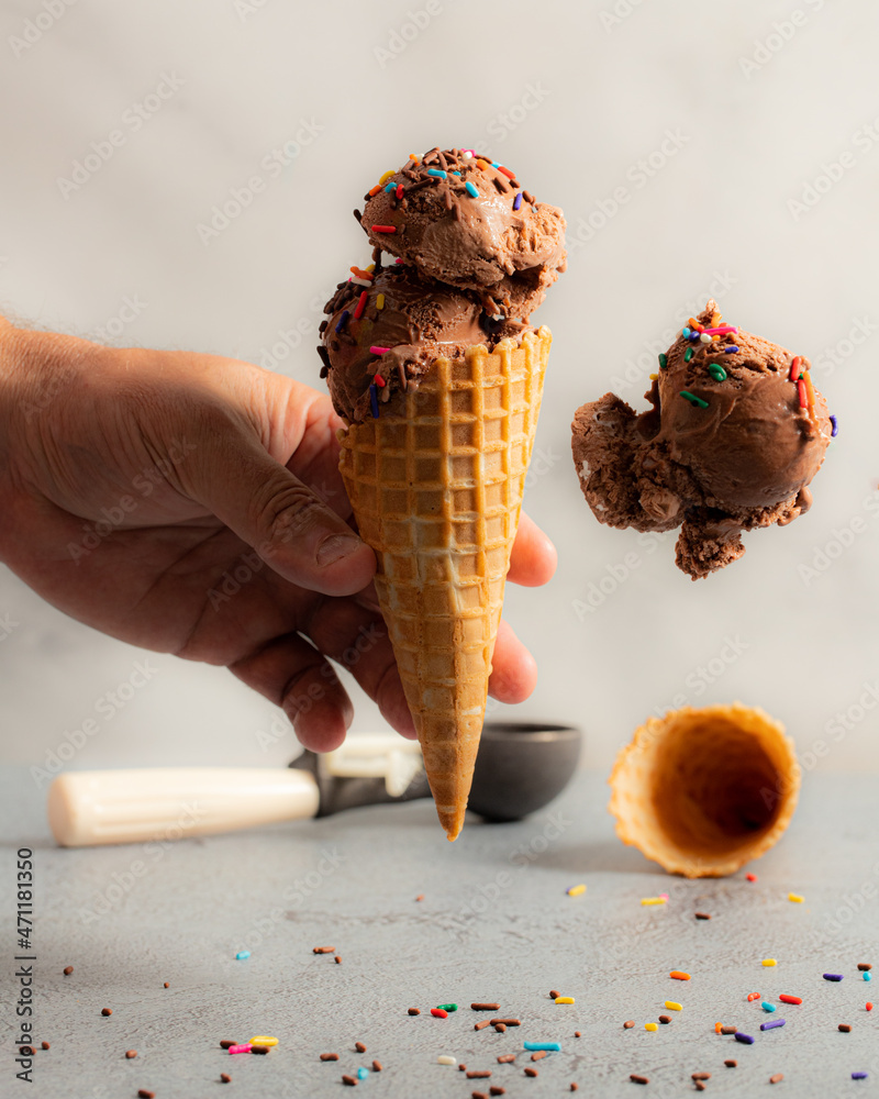 Triple scoop chocolate ice cream cone with sprinkles, with the top ...