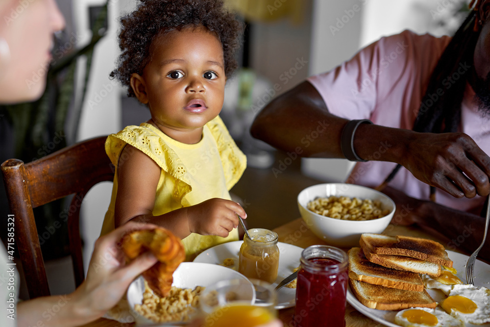 Child having breakfast. Kid girl eating poridge with fruit. Little girl ...