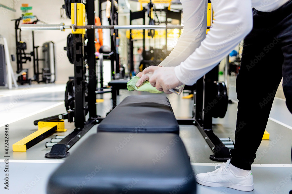 Photo Stock Young man cleaning and disinfecting with sanitizer the gym ...