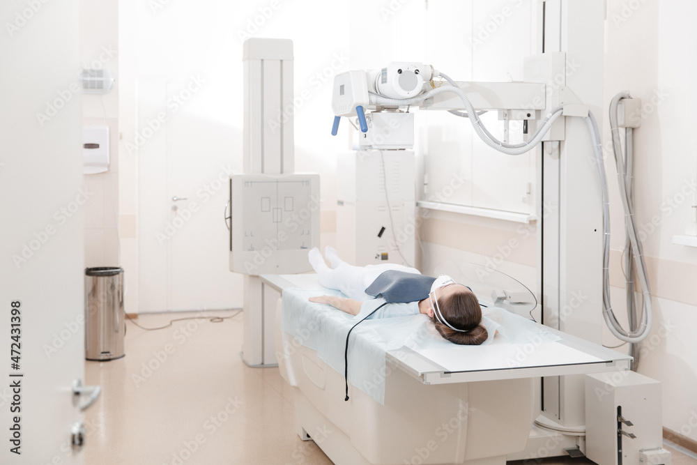 Doctor taking x-ray of patient lying on gurney. Hospital radiology room ...