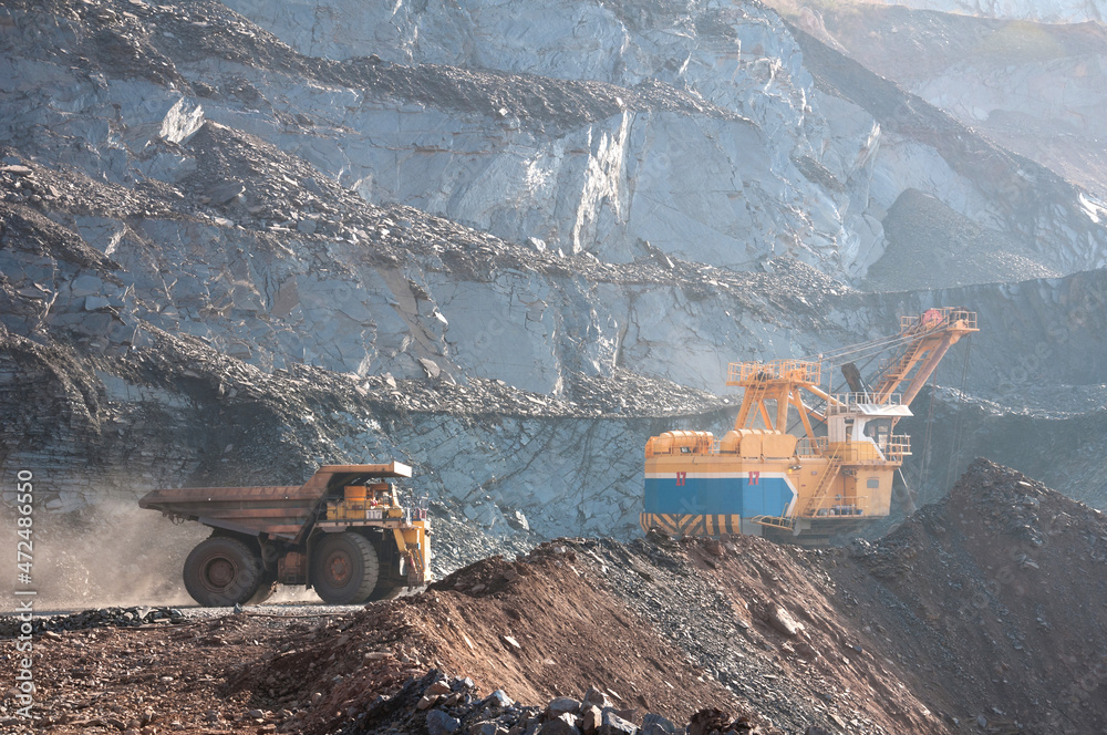 open cast mine dump trucks drive alone industrial area of iron ore ...