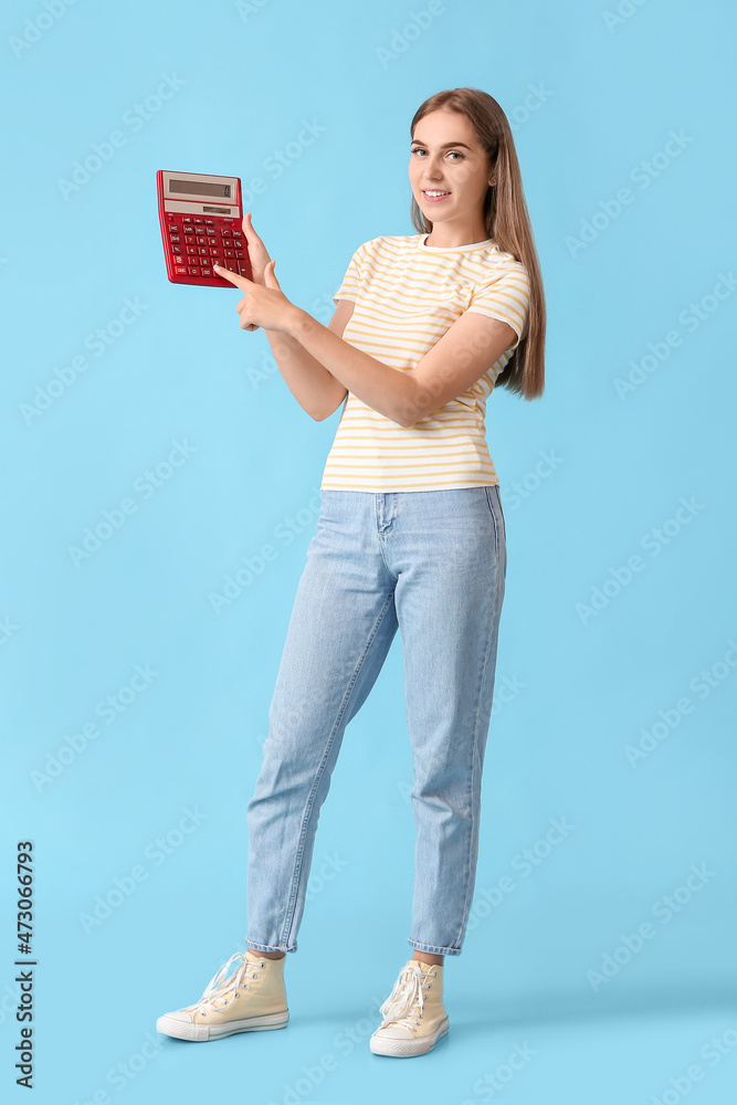 Pretty young woman with calculator on blue background Stock Photo ...