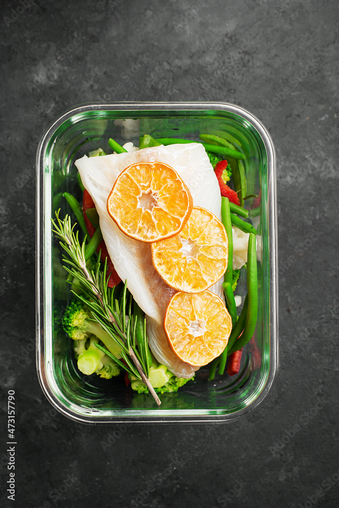 White cod fish fillet box. Fresh vegetables with a slice of cod in a ...