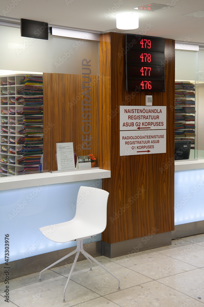 Waiting area and reception desk at a modern hospital, with signs and ...