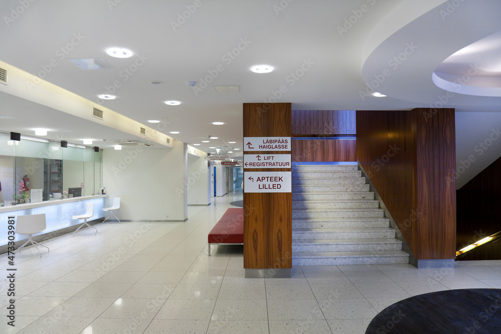 Waiting area and reception desk at a modern hospital, with signs and ...