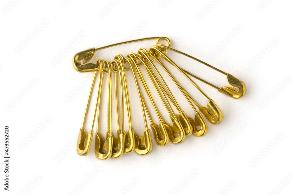 gold color safety pins, commonly used to fasten clothing, isolated on ...