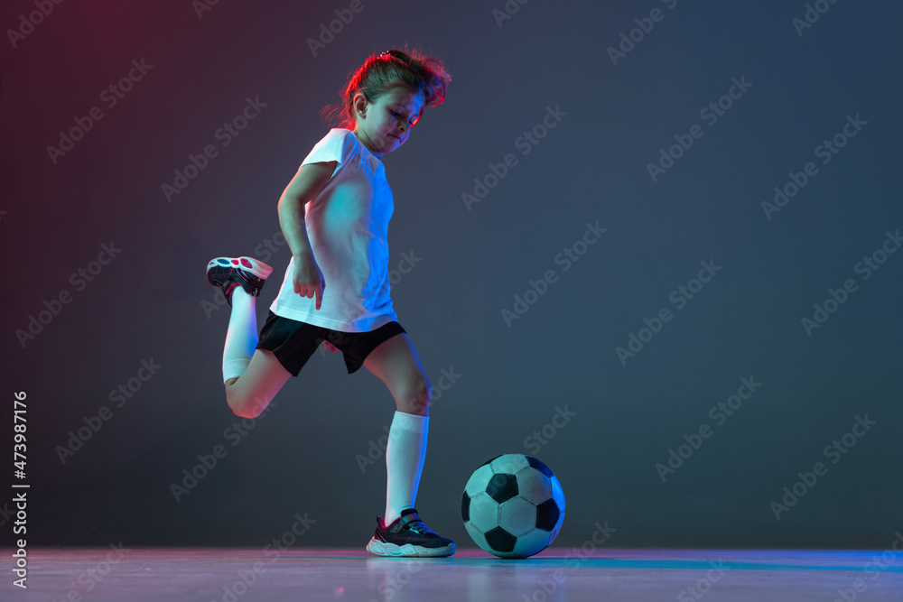 Full-length horizontal portrait of little girl playing football ...