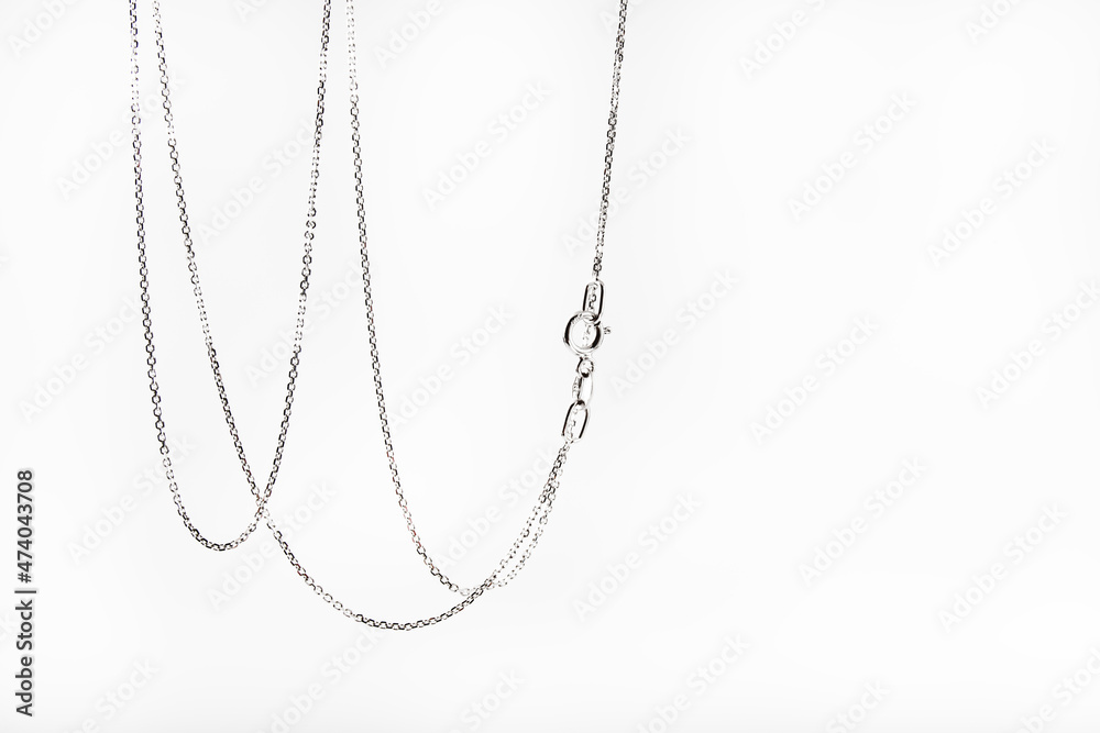 Silver chain hanging on a white background. Stock Photo | Adobe Stock