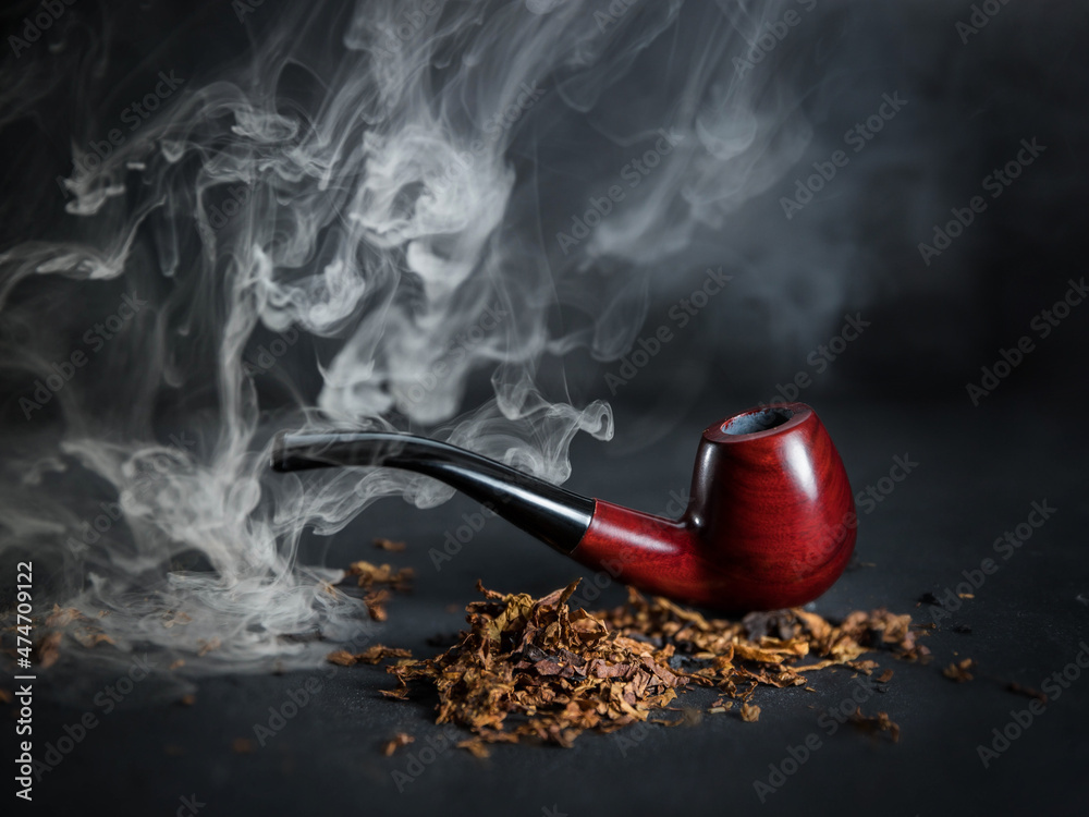 Smoking pipe, tobacco and smoke on a black background . Relax ...