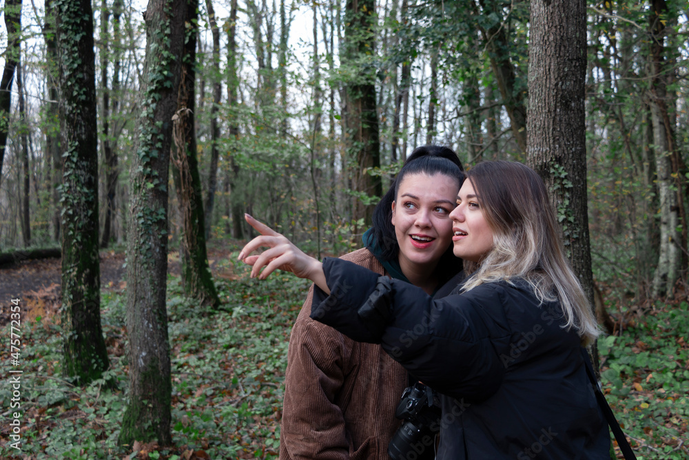 Sibling concept photo. One of the sisters is showing the other a place ...