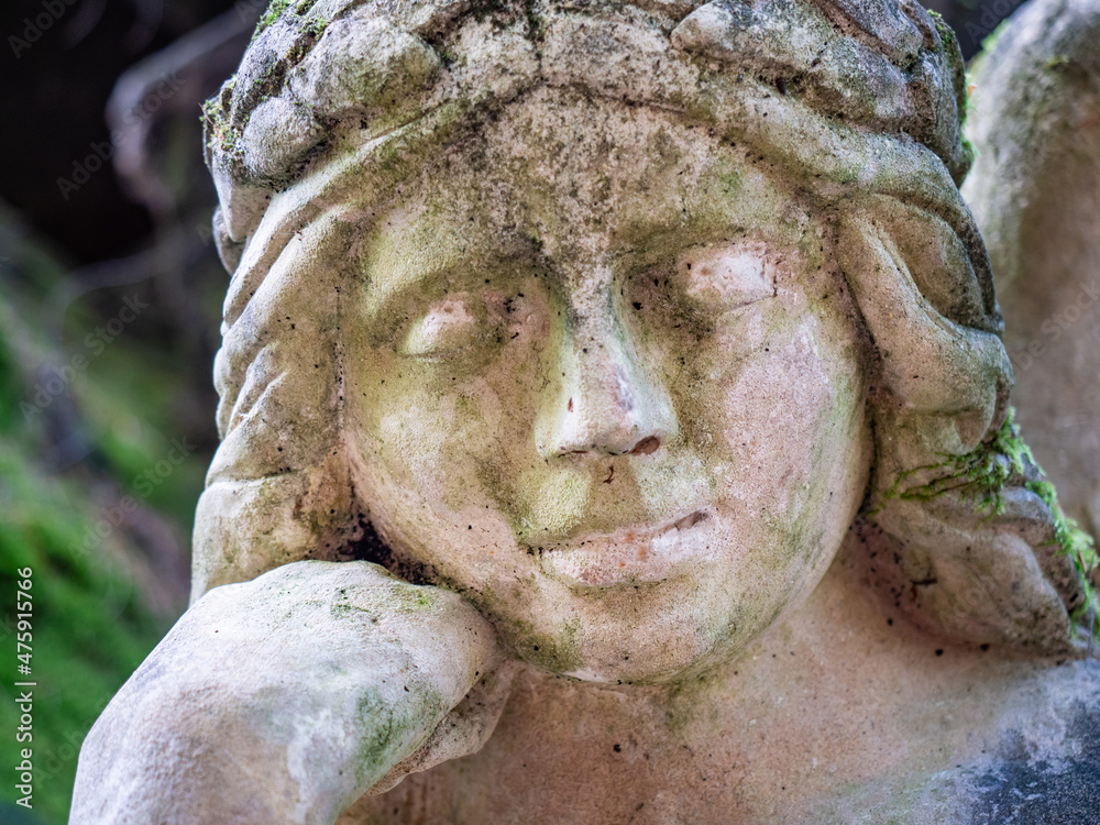 Antique statue of an smilling angel in ancient style. Statue at forest ...